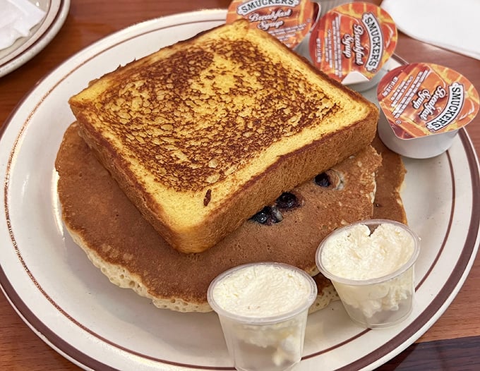 Breakfast identity crisis in the best possible way—golden French toast atop blueberry pancakes. Like getting the window and aisle seat simultaneously.