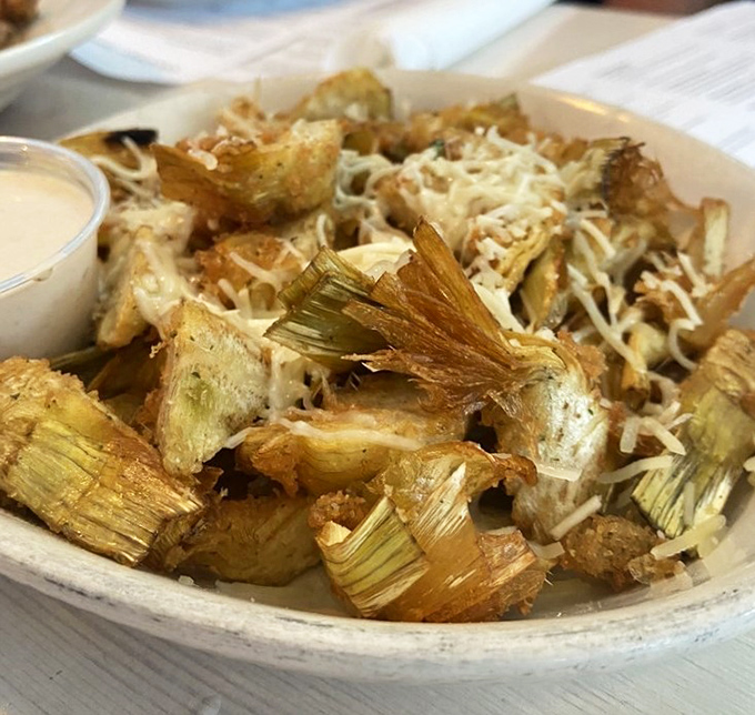 These fried artichoke quarters aren't just appetizers—they're little golden tickets to happiness, complete with a shower of parmesan that means business.