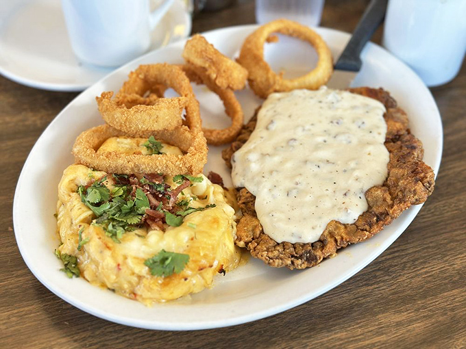 Country fried steak smothered in peppery gravy alongside scrambled eggs—a plate that says "take the rest of the day off, you've earned it."