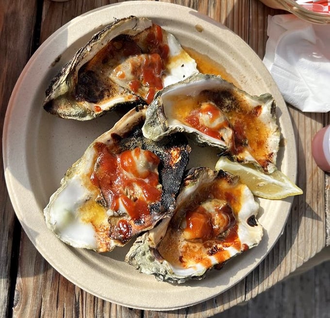 These grilled oysters aren't just seafood—they're little volcanic islands of flavor erupting with savory butter and tangy sauce.