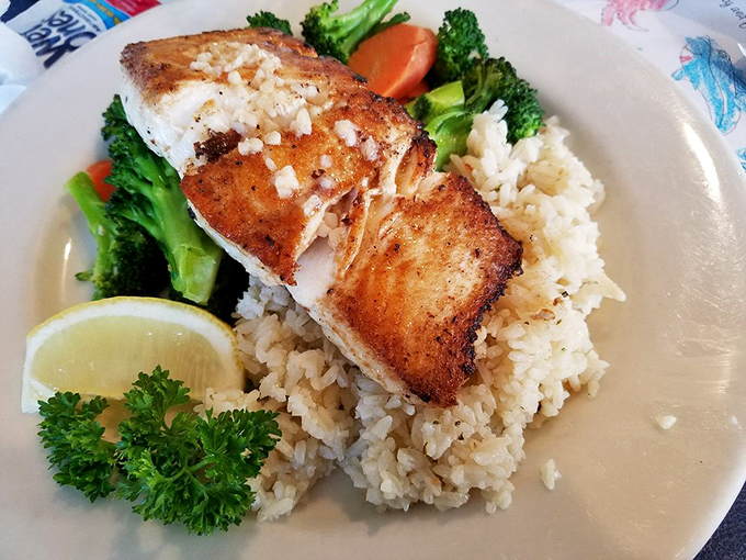 Simplicity at its finest—perfectly grilled fish atop rice with vibrant vegetables. Sometimes the least complicated dishes require the most skill to execute this beautifully.