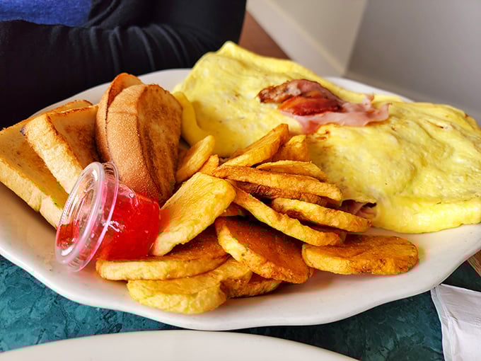 This omelet doesn't need Instagram filters—it's showing off naturally with those golden home fries standing guard like delicious sentinels.