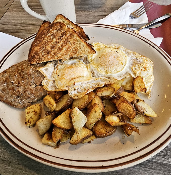 The breakfast trinity: perfectly crispy home fries, eggs with sunshine-yellow yolks, and toast ready for butter. Morning salvation has arrived.