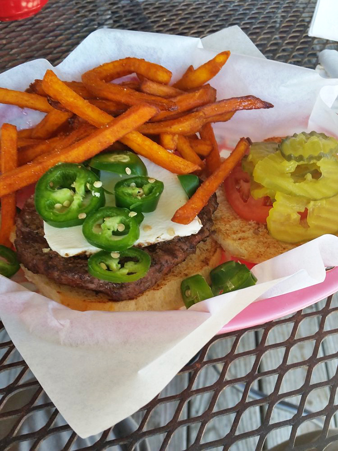 A burger that doesn't whisper, it announces itself—crowned with jalapeños that mean business and sweet potato fries that deserve their own fan club.