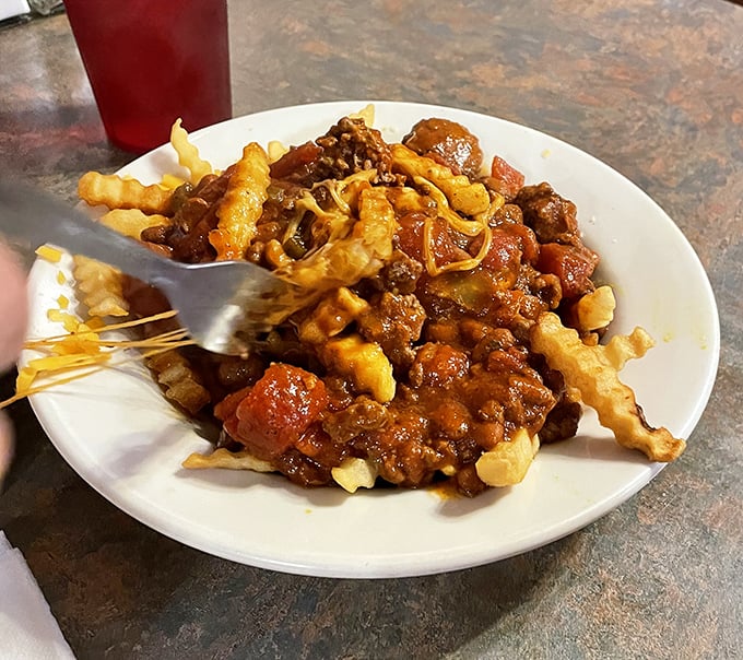Chili cheese fries that laugh in the face of diet culture. This glorious mess of savory sauce, melted cheese, and crispy potatoes demands a fork—and zero regrets.
