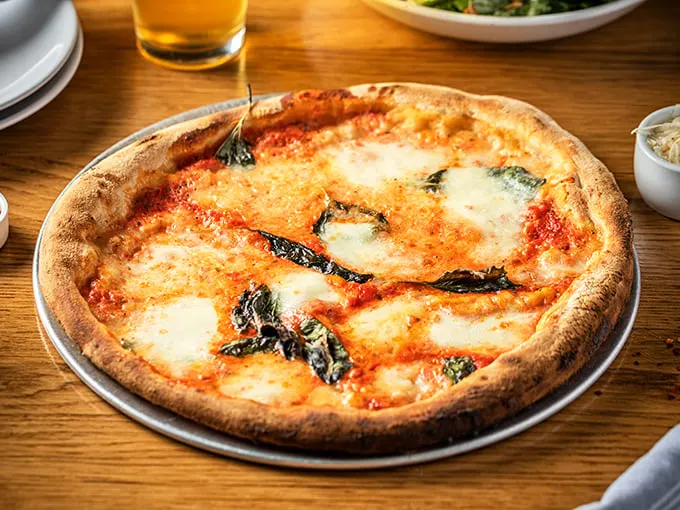The Margherita pizza—proof that simplicity, when executed perfectly, is the highest form of culinary art. Those char spots are flavor freckles!