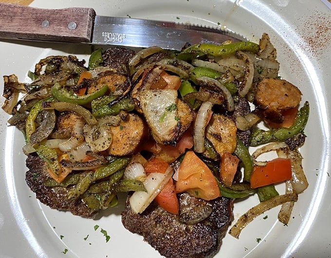 Vegetables dancing around a perfectly seasoned steak—proof that sometimes the best relationships are the ones that sizzle together on a hot grill.