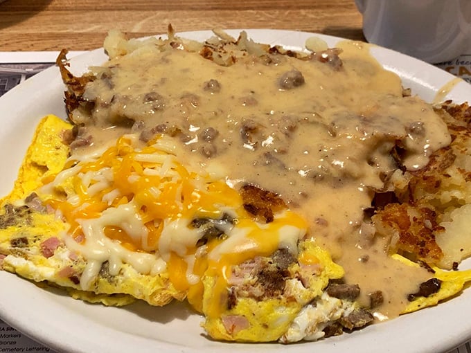 This isn't just an omelet—it's a cheesy, meaty masterpiece smothered in country gravy that would make your cardiologist frown and your taste buds sing.