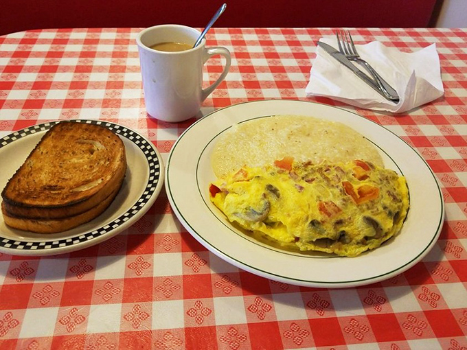 Morning masterpiece alert! A fluffy omelet packed with veggies alongside perfectly golden toast – the breakfast equivalent of hitting all green lights on your morning commute.
