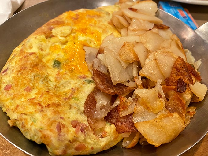 This isn't just an omelet—it's a perfect golden envelope delivering a message of breakfast joy, with hash browns that deserve their own fan club.
