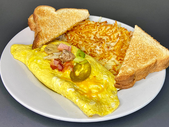 Breakfast perfection on a plate: a fluffy omelet with golden hashbrowns and perfectly toasted bread. Morning salvation for the hungry soul.