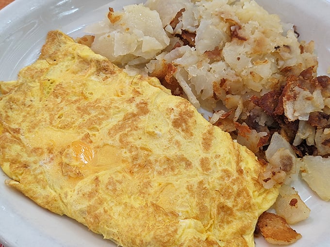 A perfect omelet that's somehow both cloud-like and substantial, paired with home fries that deserve their own fan club.