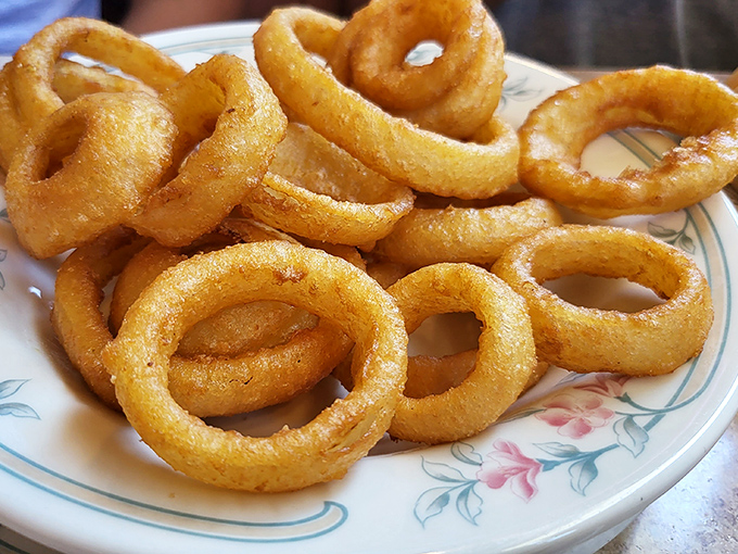 Golden onion rings with the perfect crunch-to-tenderness ratio – the kind that make you wonder why anyone bothers with fancy appetizers.