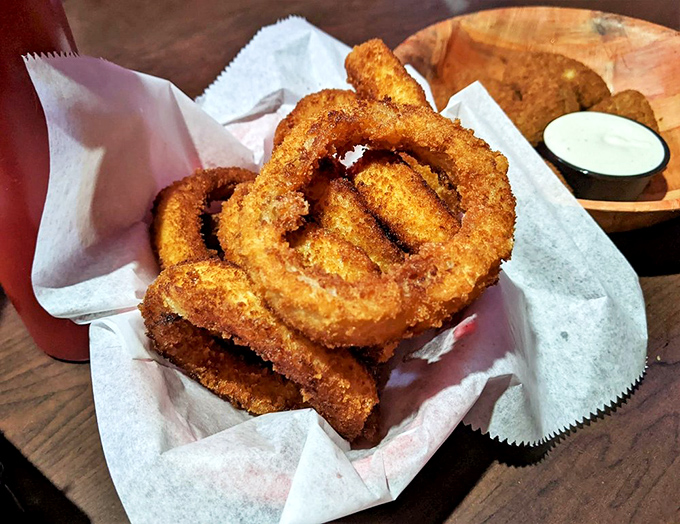 These golden onion rings tower like edible skyscrapers, crispy perfection in every golden bite.