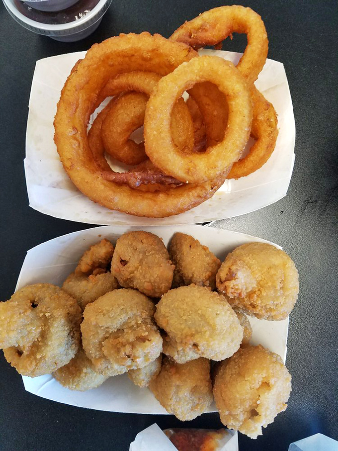 Golden halos of onion rings alongside mushroom morsels—fried to that mythical point where crunch meets tenderness. Dipping sauce not optional.