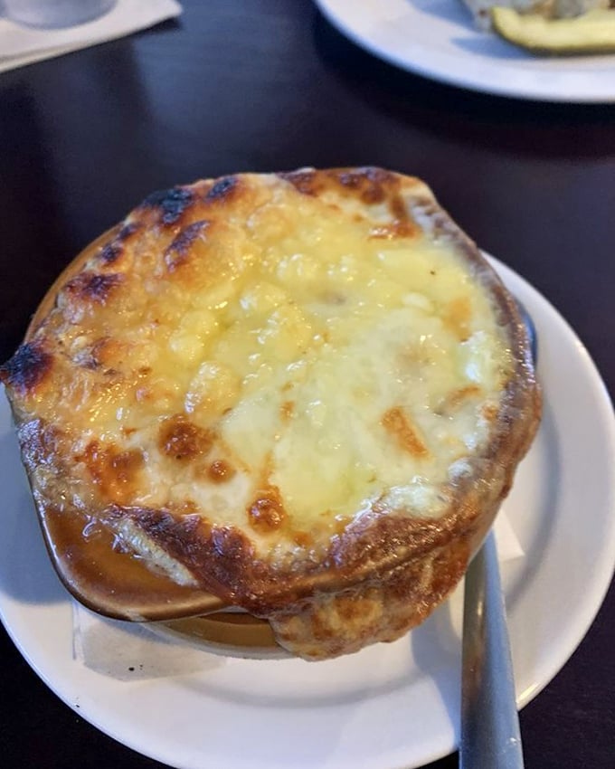 Bubbling cheese creates a golden canopy over this French onion soup—a bowl that understands sometimes the best things in life require a spoon.