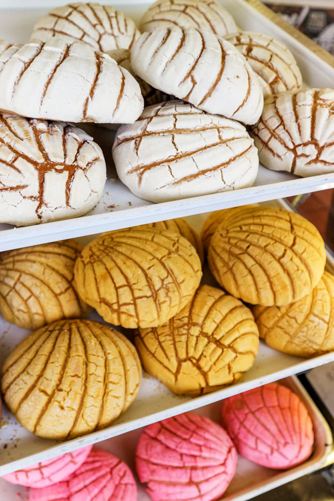 Sweet, crackle-topped conchas in white, yellow, and pink – the Mexican bakery equivalent of choosing your fighter. Spoiler alert: they're all winners.