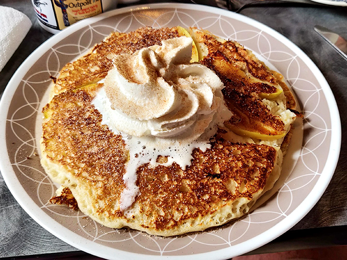 Pancake poetry in motion—golden, crispy edges giving way to fluffy centers, crowned with a cloud of whipped cream. Breakfast doesn't get more photogenic than this.