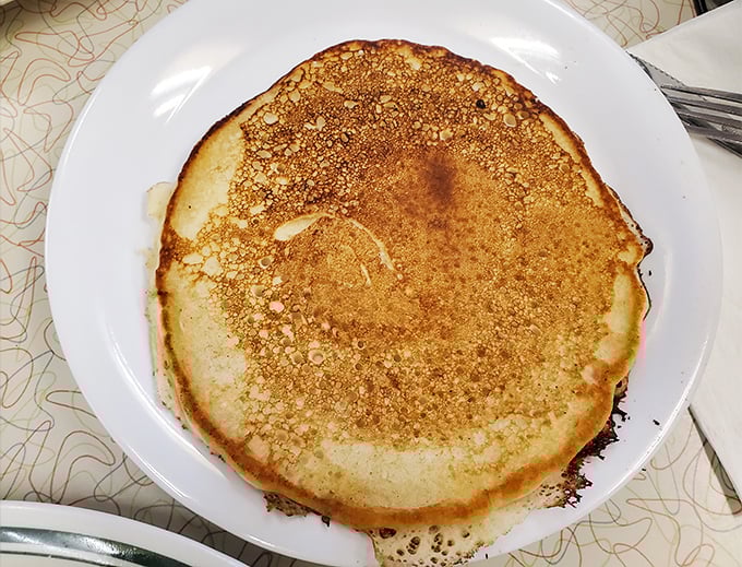 This pancake doesn't just hang over the edge of the plate—it's staging a full-blown territorial expansion.