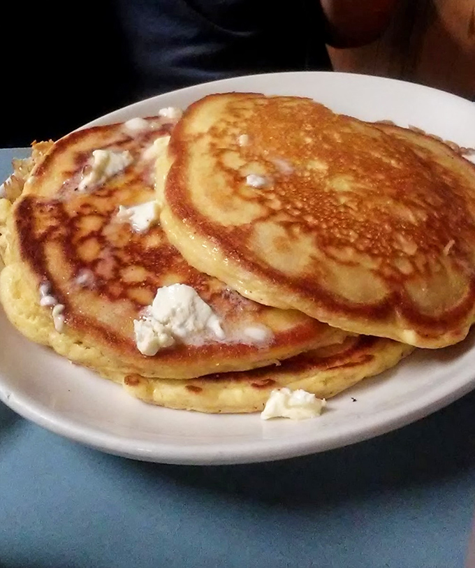 Golden pancakes with melting butter pats that create little pools of deliciousness—the breakfast equivalent of jumping into a perfect swimming hole.