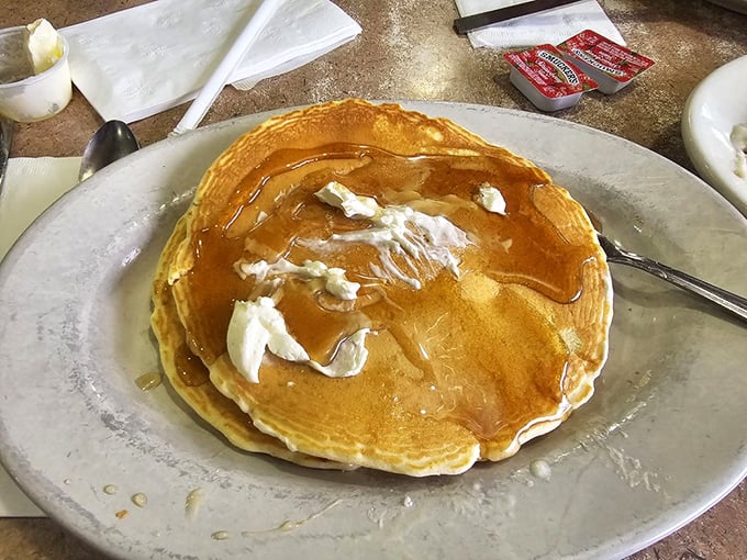 Pancakes so perfectly golden they belong in Fort Knox, with butter melting like a sunrise over a delicious horizon.