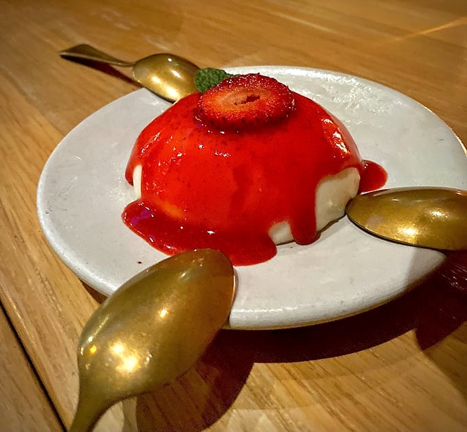 Panna cotta that jiggles just right, crowned with strawberry and surrounded by golden spoons like royal attendants.