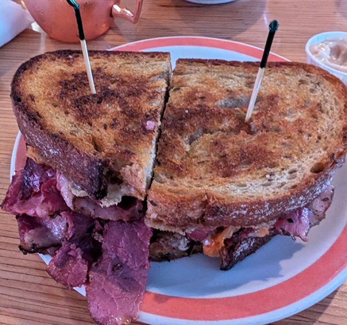 A Reuben sandwich that means business. Pink pastrami piled high between golden rye, proving that sometimes the classics deserve their legendary status.