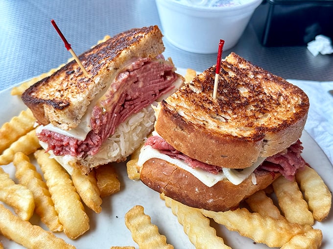 This towering pastrami sandwich stacked high with crispy fries represents the art of deli perfection done right.