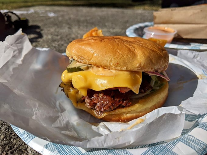 Pastrami and burger unite in holy matrimony on wax paper, creating a sandwich alliance that would make diplomats jealous.