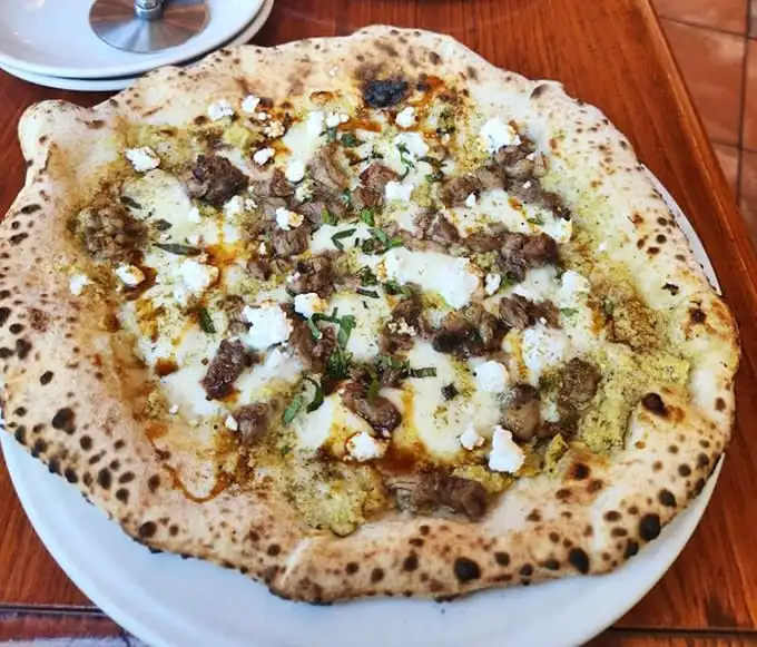 The perfect Neapolitan pizza isn't just food—it's performance art with a blistered crust that crackles like vinyl records and toppings that sing in harmony.
