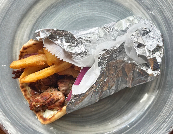 The pork souvlaki arrives wrapped like a present you can't wait to unwrap. The Greeks knew what they were doing when they invented this portable perfection.