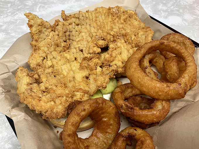 The pork tenderloin—pounded thin and fried to golden perfection—follows Indiana's unwritten rule: the meat must comically exceed the bun's circumference by at least 200%.