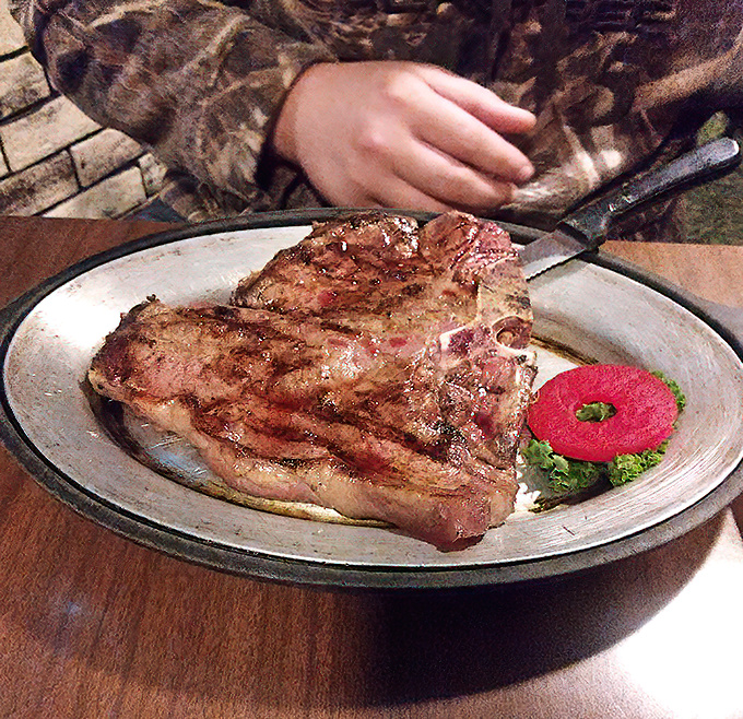 A porterhouse steak that would make Ron Swanson weep tears of joy—perfectly seared and ready for its close-up.