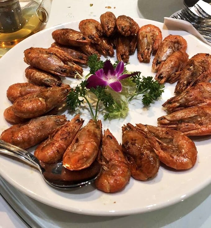 A crown of prawns arranged like they're posing for their royal portrait. That purple orchid isn't just garnish—it's announcing "this is no ordinary seafood."