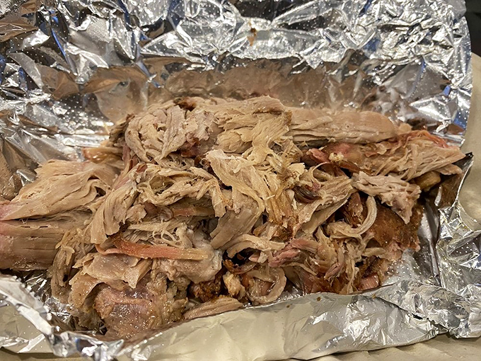 Pulled pork that looks like it's been practicing social distancing from itself—each strand perfectly separated after a long, smoky spa treatment.