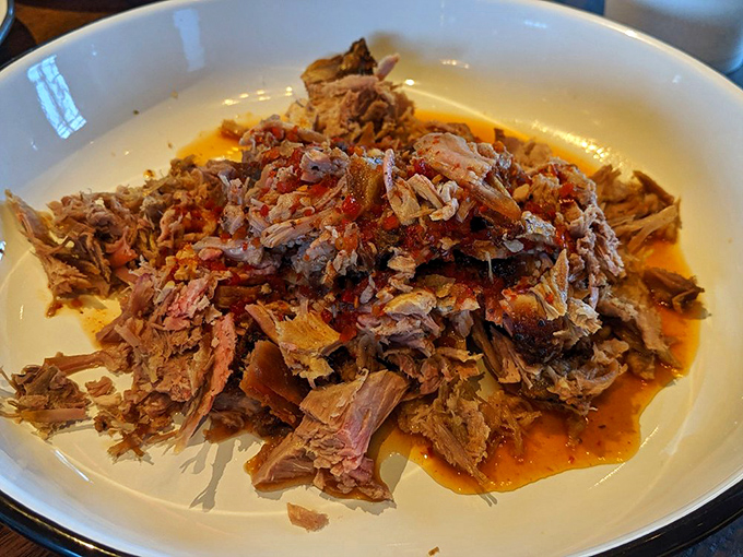 Pulled pork that practically melts on contact—tender, juicy, and swimming in a sauce that balances tang and sweetness like a culinary tightrope walker.
