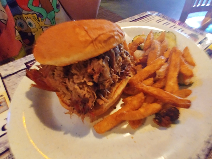 The pulled pork sandwich arrives like a mountain of smoky goodness, ready to challenge your jaw's capacity and reward your taste buds' patience.
