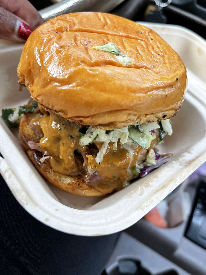 This isn't just a sandwich—it's an architectural marvel of pulled pork, slaw, and sauce that requires both hands and several napkins.