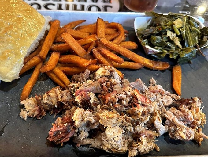 Pulled pork that's clearly been introduced to smoke and time—the two best friends meat can have. Those sweet potato fries and collards aren't just sides, they're supporting actors deserving of awards.