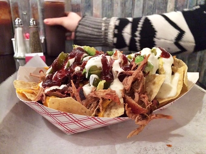 These loaded nachos aren't just a meal—they're an architectural achievement of pulled pork, sauce, and toppings that somehow maintains structural integrity.
