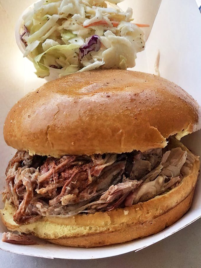 This pulled pork sandwich isn't messing around. The golden bun barely containing its smoky treasure while the slaw stands by, ready for its supporting role.