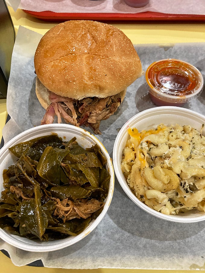 The holy trinity of barbecue bliss: pulled pork sandwich, collard greens, and mac 'n cheese. Name a more perfect trio—I'll wait.
