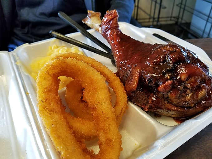 The holy trinity of BBQ bliss: a glistening chicken leg, golden onion rings, and mac and cheese that could make a cardiologist weep.