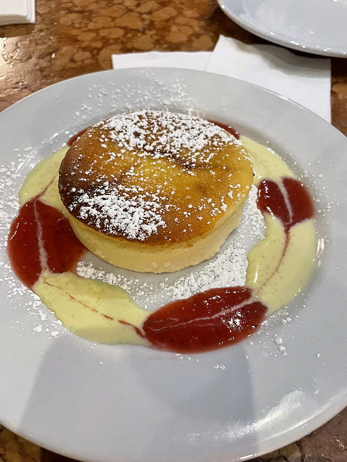 This isn't just cheesecake—it's a golden-topped ricotta masterpiece floating on custard seas with berry archipelagos. Dessert geography at its finest.