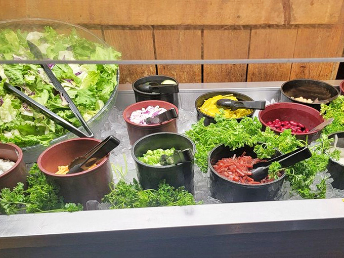 A salad bar that actually deserves respect—fresh, vibrant ingredients waiting to balance out your carnivorous main course. Guilt management at its finest.