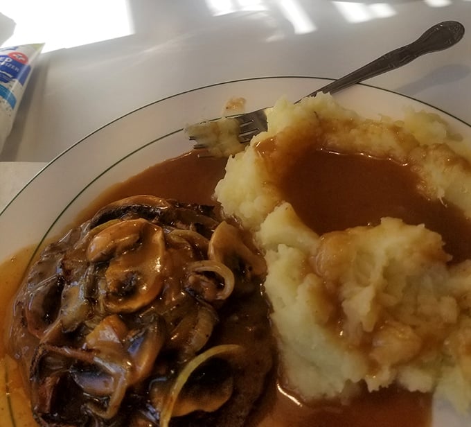 Salisbury steak with mushroom gravy and mashed potatoes—the kind of plate that makes you want to call your cardiologist just to brag about it.