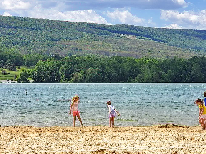 Children test the waters at the sandy beach, performing the universal "is it cold?" dance that transcends generations and geography.