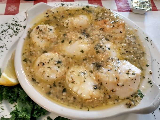 These scallops swim in buttery, herb-flecked glory – proof that simple preparations often yield the most sublime results when quality ingredients take center stage.