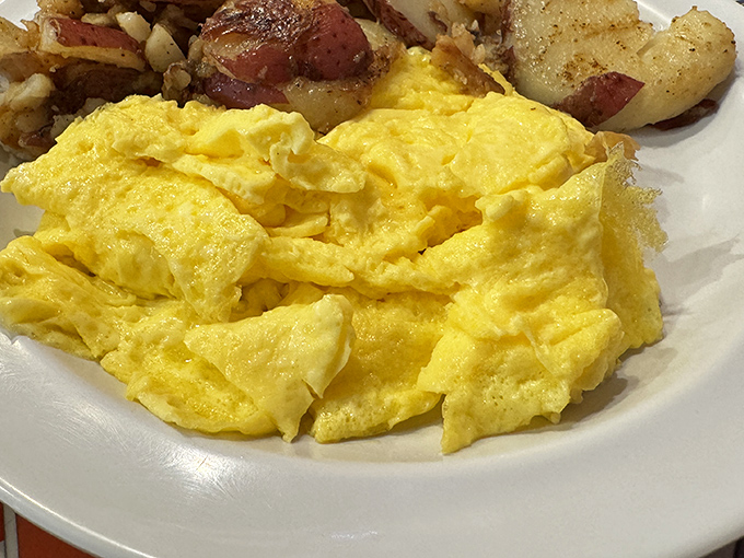 Scrambled eggs that actually look like eggs, not some sad hotel buffet afterthought. Paired with home fries that clearly never met a freezer.
