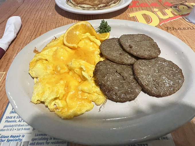 Fluffy scrambled eggs and perfectly browned sausage patties—proof that breakfast fundamentals, when done right, need no embellishment.
